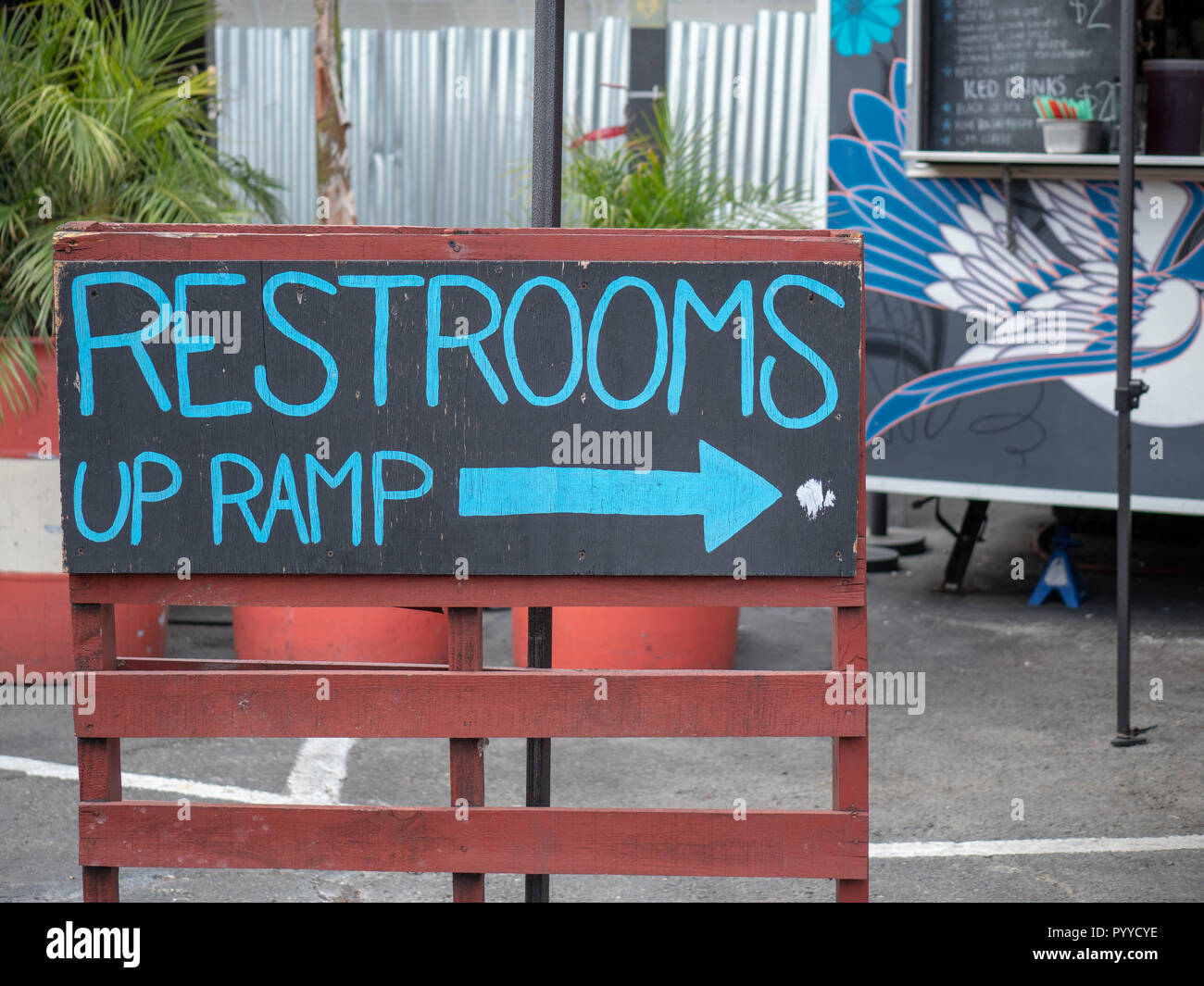 Blue handwritten restrooms up ramp sign on chalk board pointing right ...
