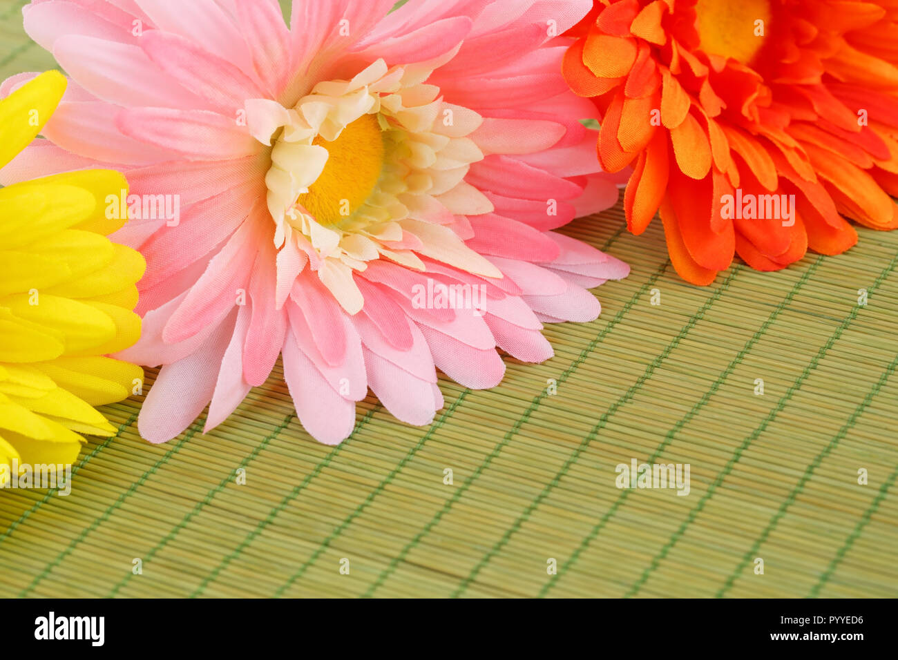 Colorful fabric daisies on bamboo background, closeup picture Stock ...