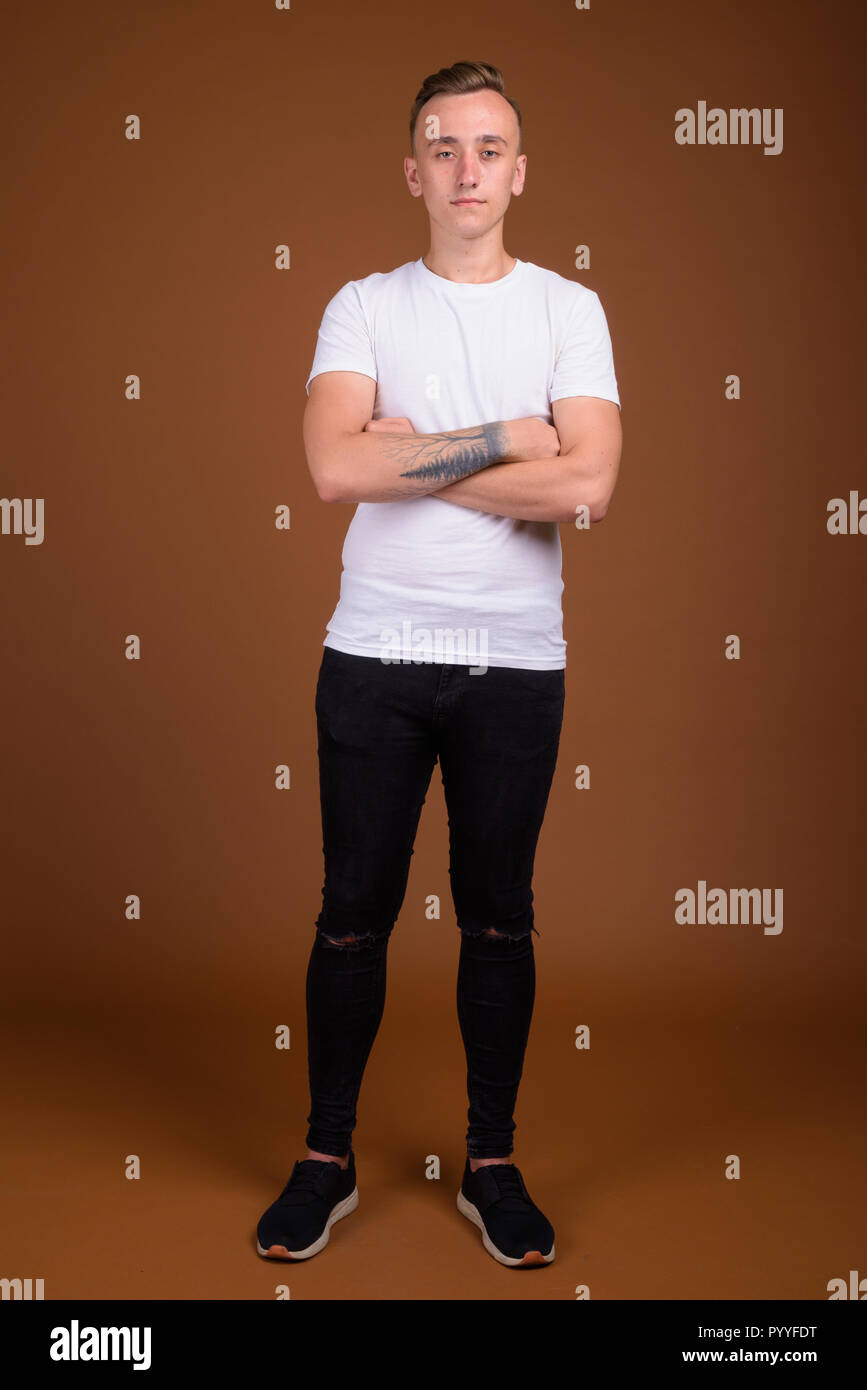 Full body shot of young handsome man with arms crossed Stock Photo - Alamy
