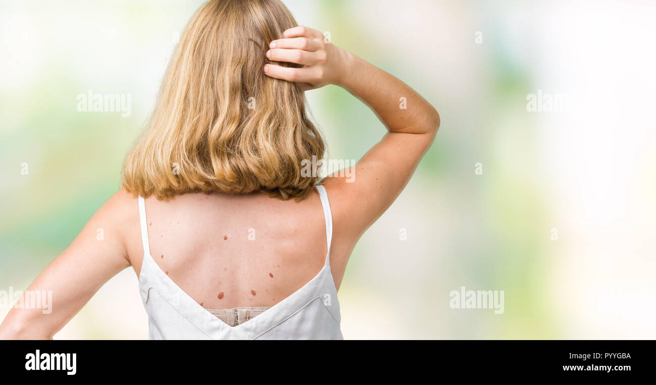 Beautiful young woman over isolated background Backwards thinking about ...