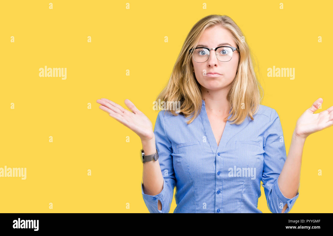 Beautiful young business woman over isolated background clueless and ...