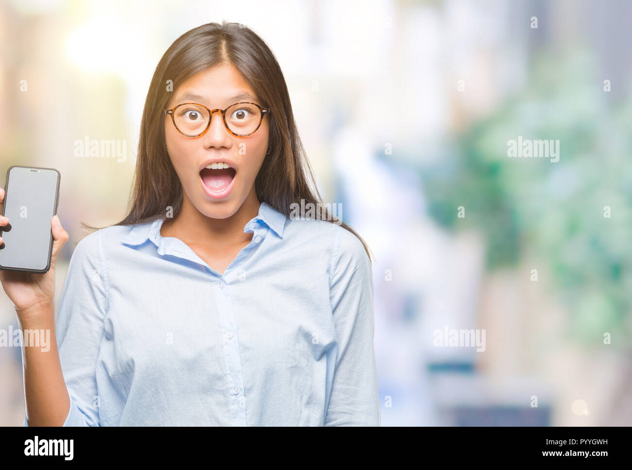 Young asian woman showing smartphone blank screen over isolated ...