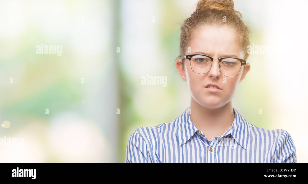 Young blonde business woman skeptic and nervous, disapproving ...
