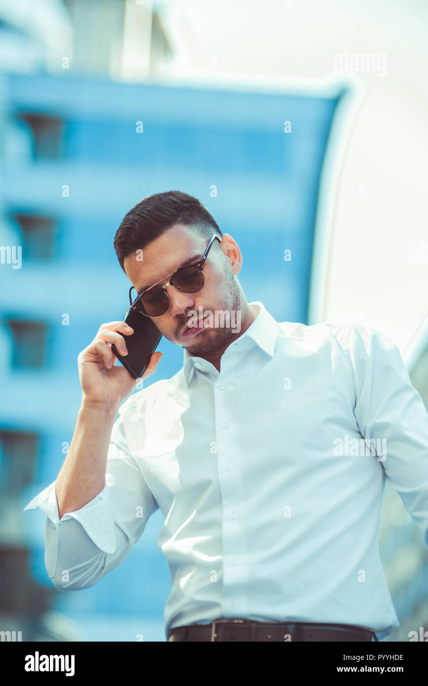 A man is on the city square, looking around him and talking to his ...