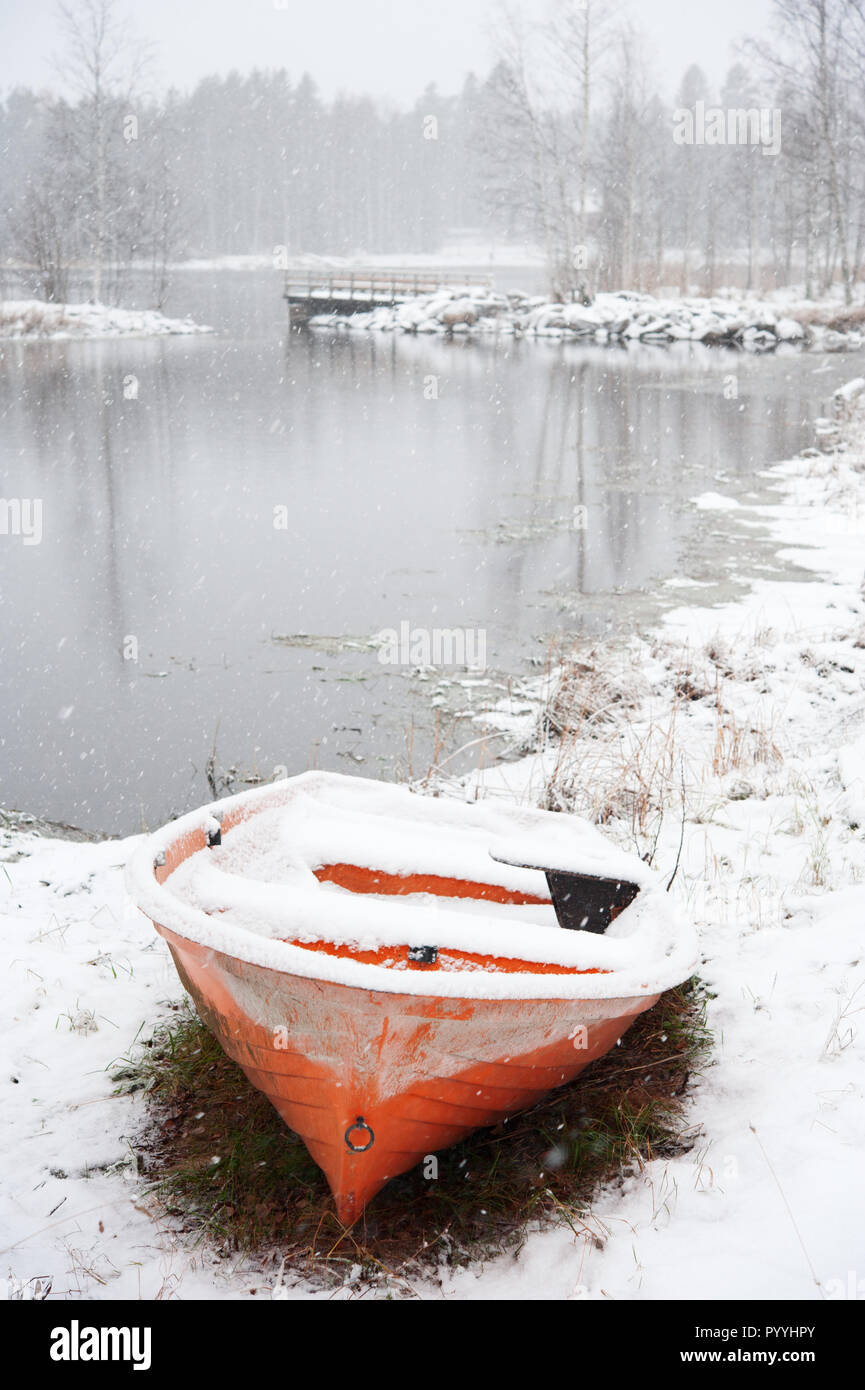 Red rowboat at lake shore in winter Stock Photo - Alamy