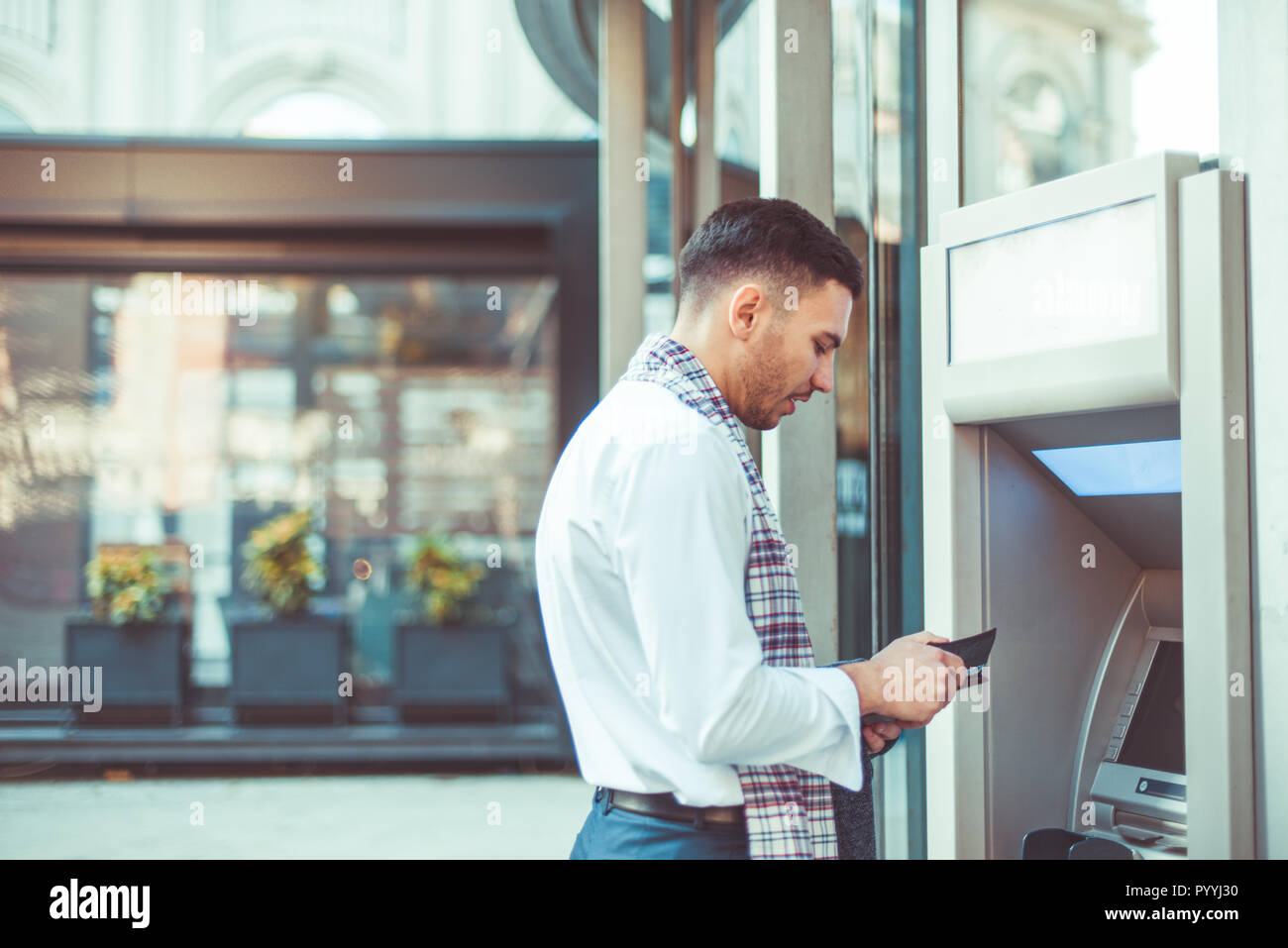 Stylish businessman in white shirt is holding his wallet and standing ...