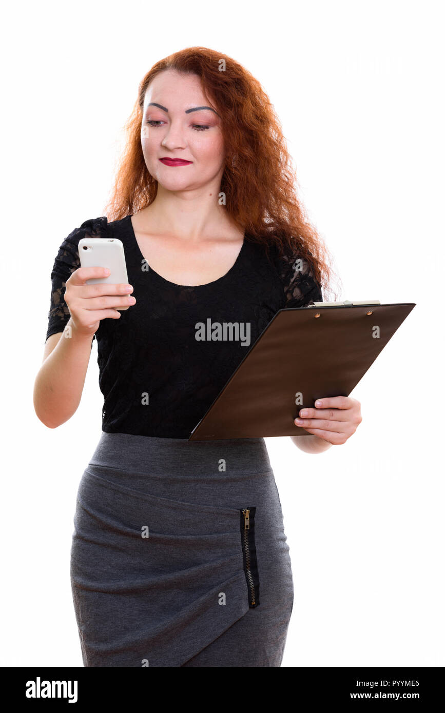 Studio shot of businesswoman holding clipboard while using mobil Stock ...