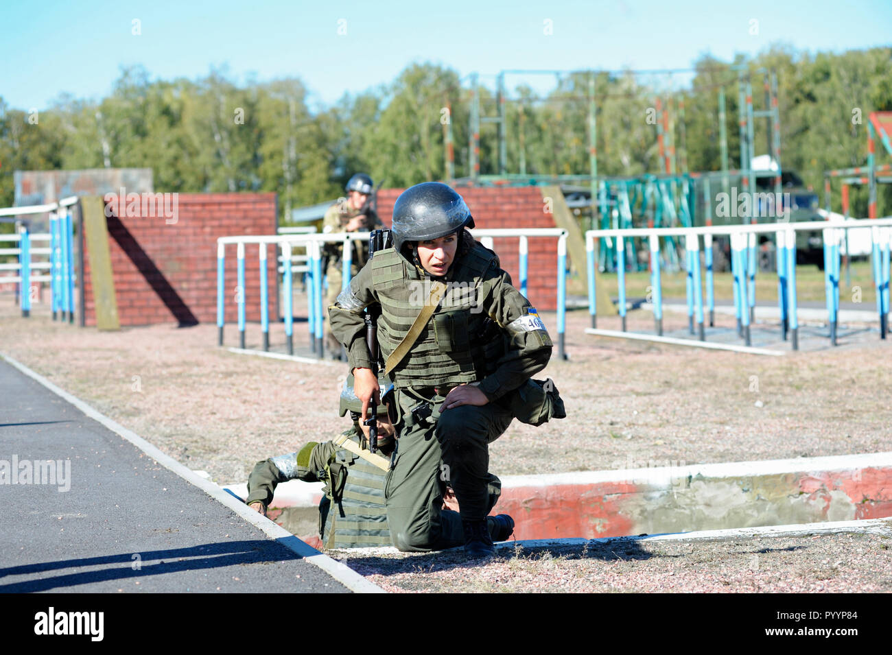 On a military training ground, obstacle course: female soldier crawling ...