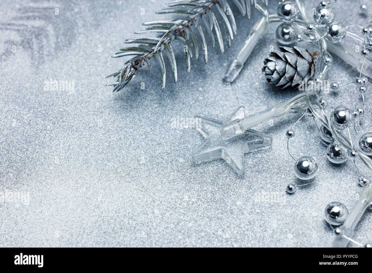 silver christmas tree branch with decorations and light garlands on ...