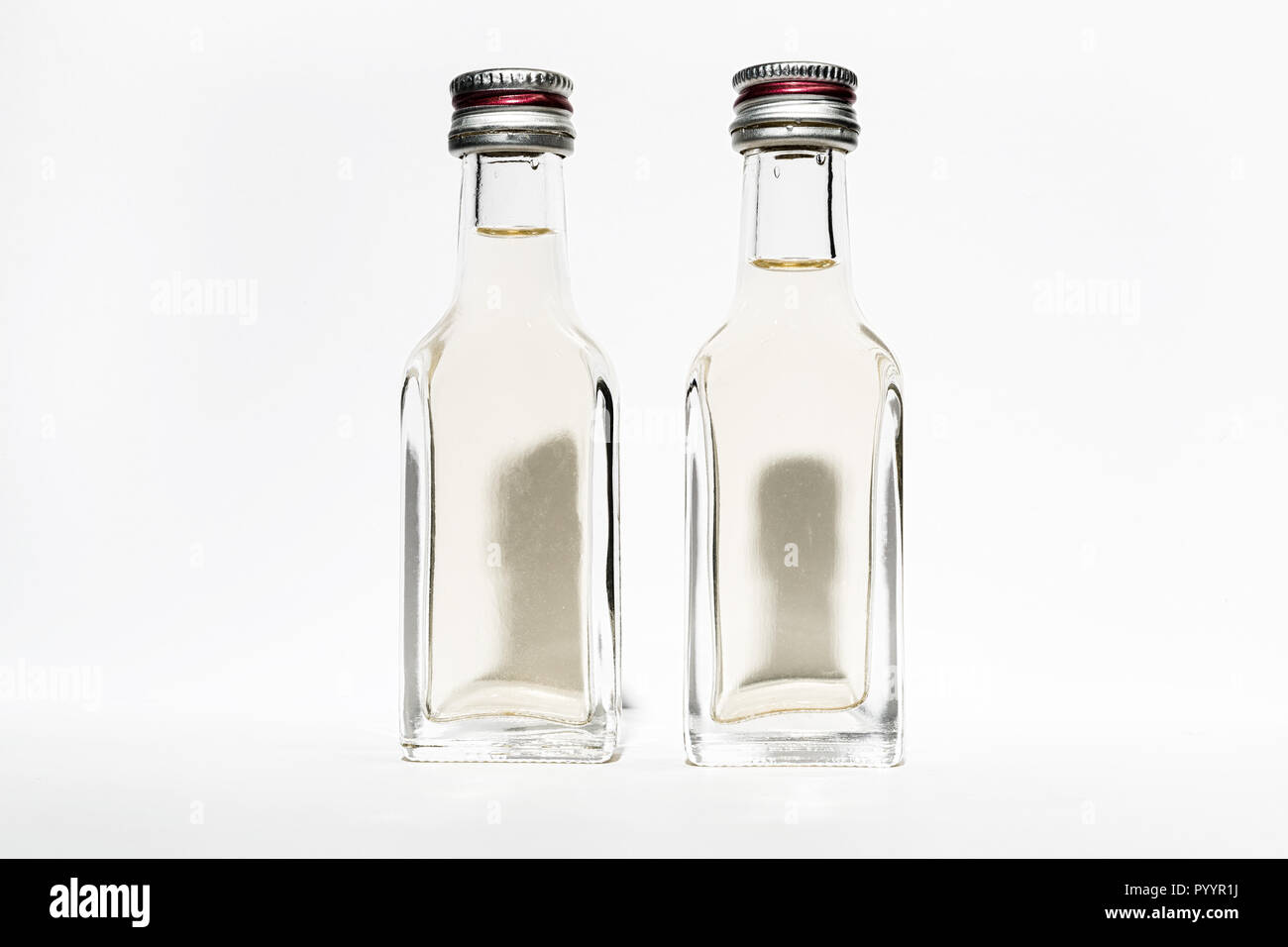 Two bottles of vintage alcohol with shadows in the shape of the heads ...