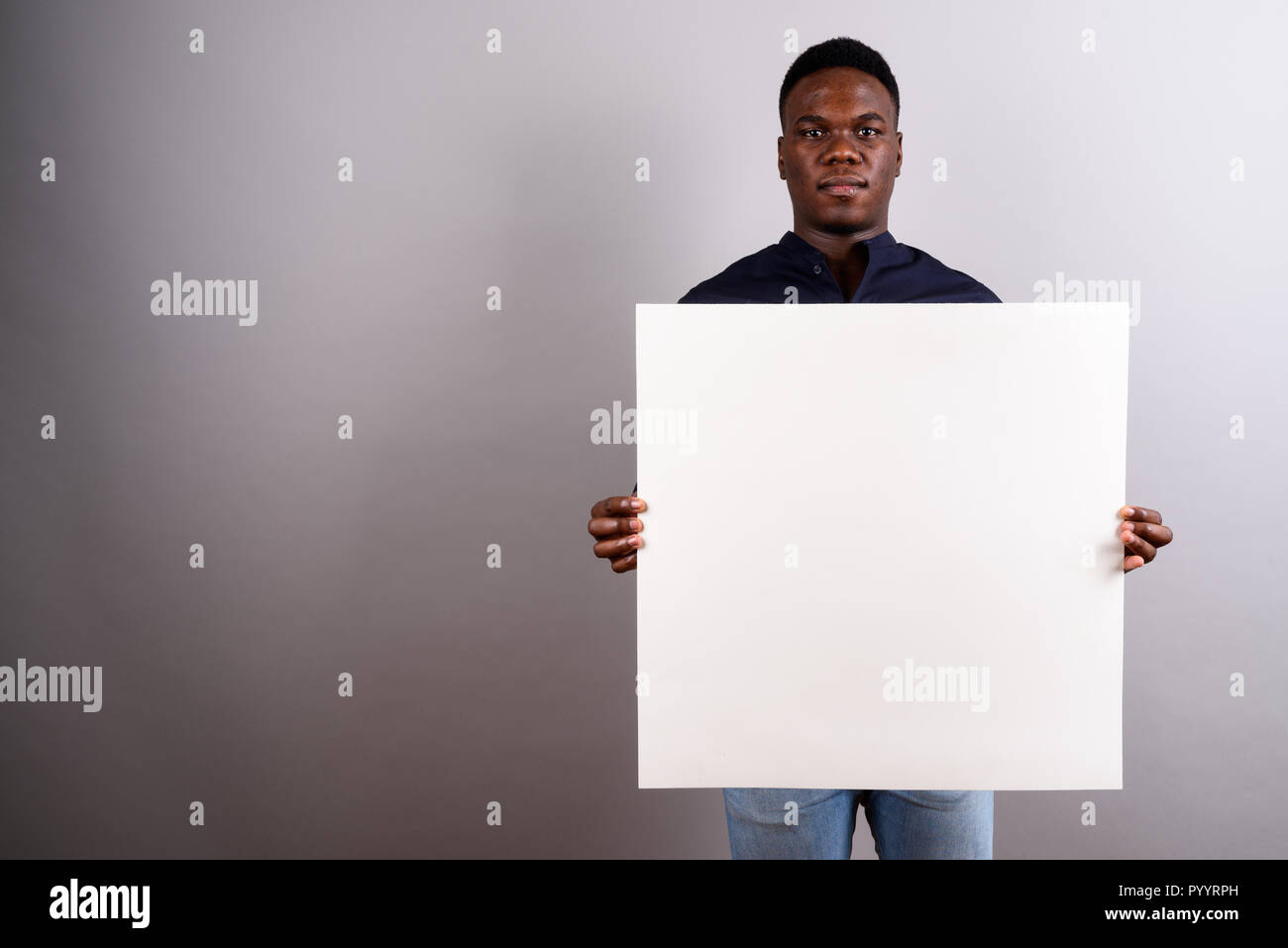 Young African businessman holding white board against white back Stock ...