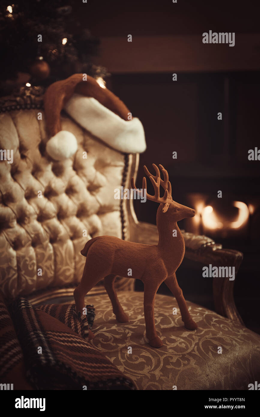Christmas by roaring log fire with reindeer and santa hat Stock Photo ...