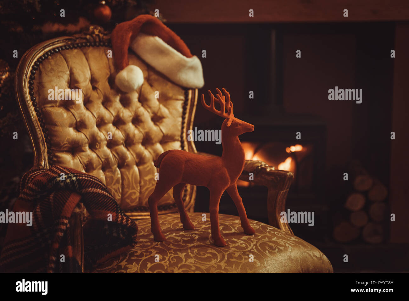 Festive Christmas Eve by a roaring log fire with santa hat and reindeer ...