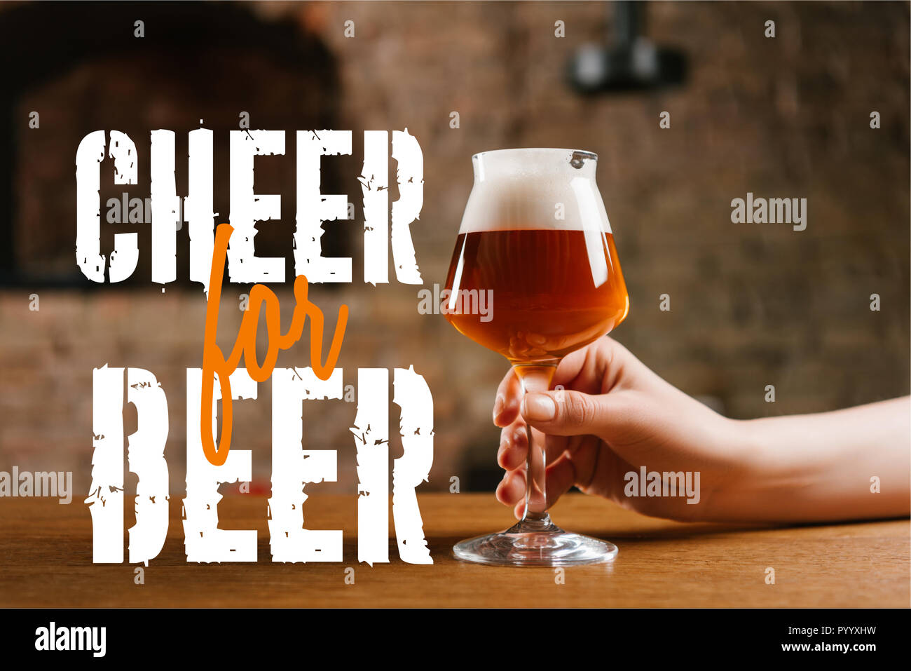partial view of person holding glass of fresh cold beer in pub with ...