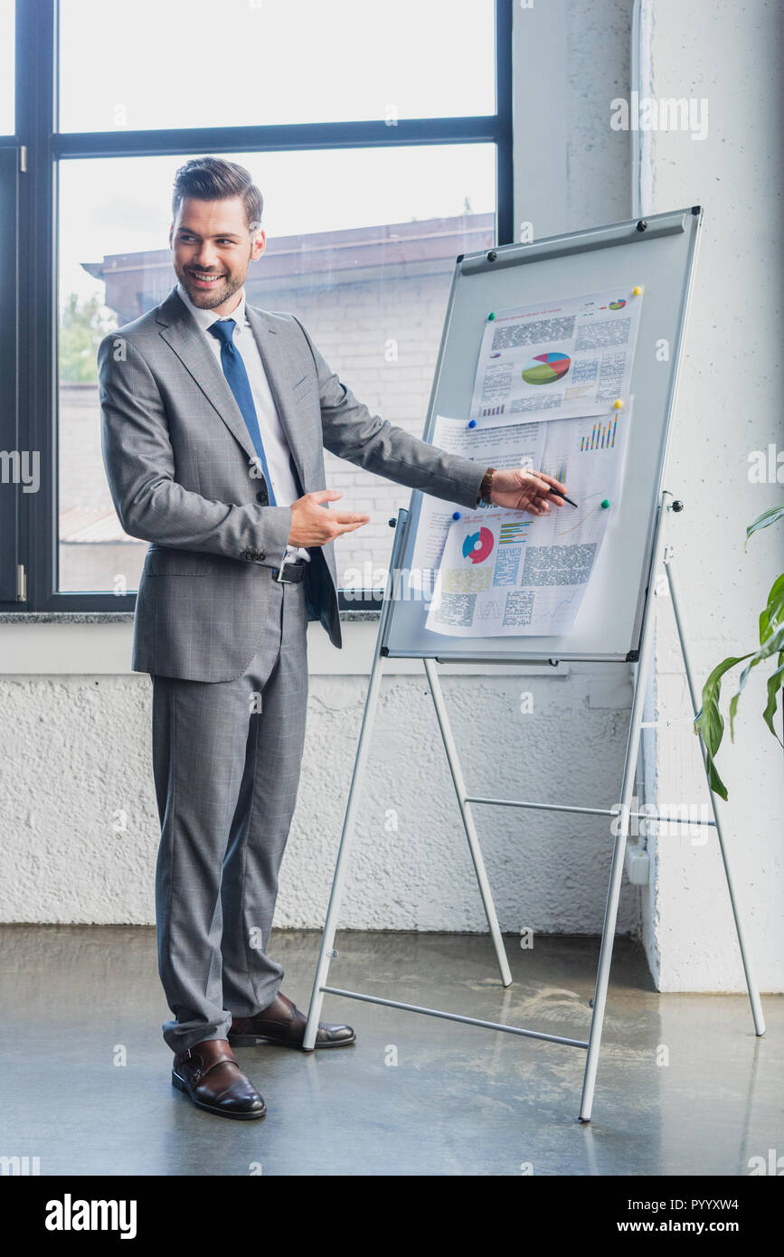 smiling young businessman pointing at whiteboard with business charts and graphs Stock Photo - Alamy