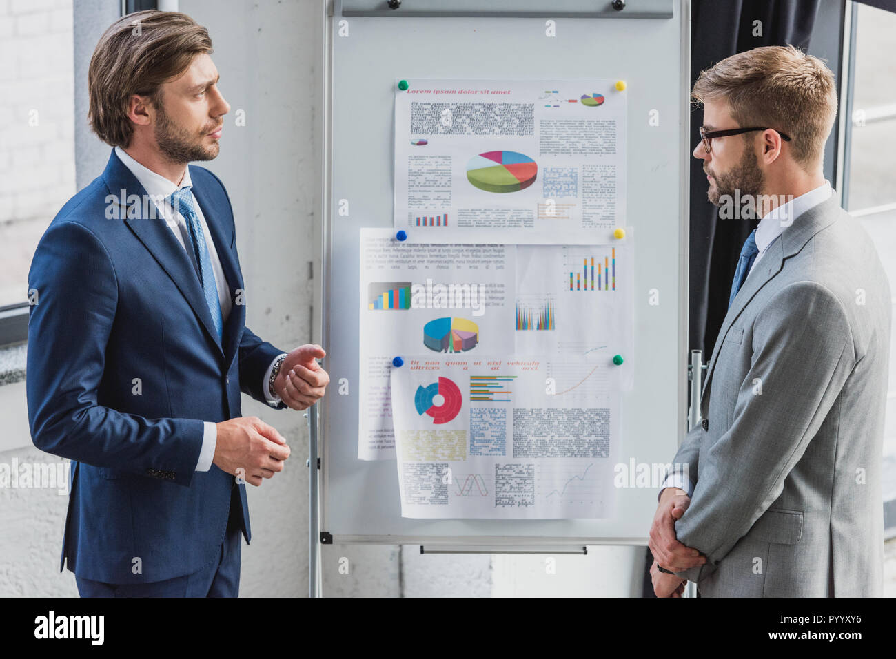 side view of professional businessmen standing near whiteboard and ...