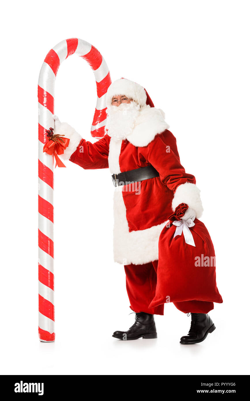 santa claus with giant candy cane and sack walking isolated on white ...