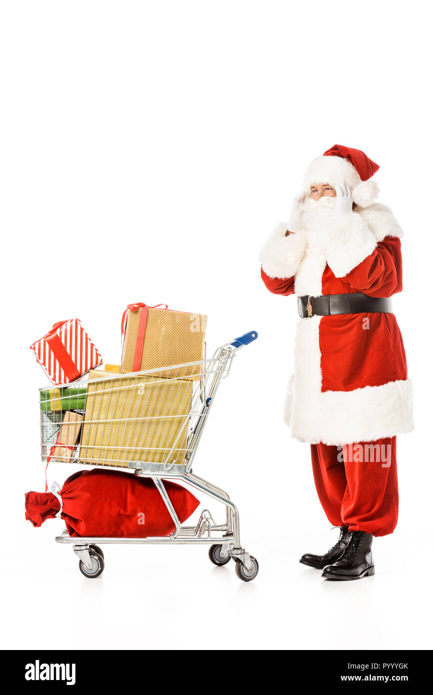 side view of santa claus with shopping cart full of gift boxes looking ...