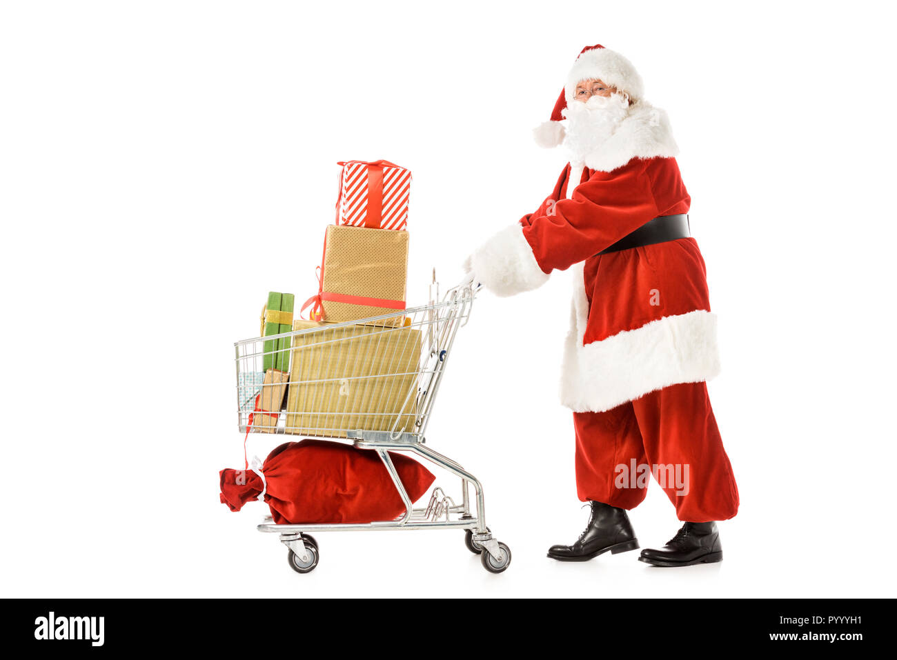 side view of santa claus walking with shopping cart full of gift boxes ...