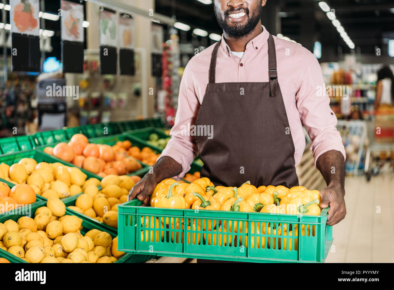 cropped image of african american male shop assistant in apron holding ...