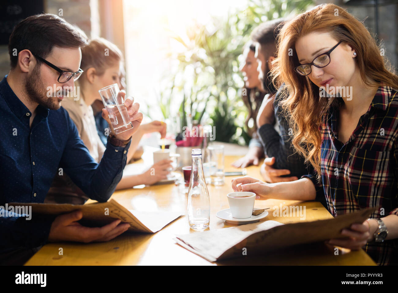 Happy colleagues from work socializing in restaurant Stock Photo - Alamy