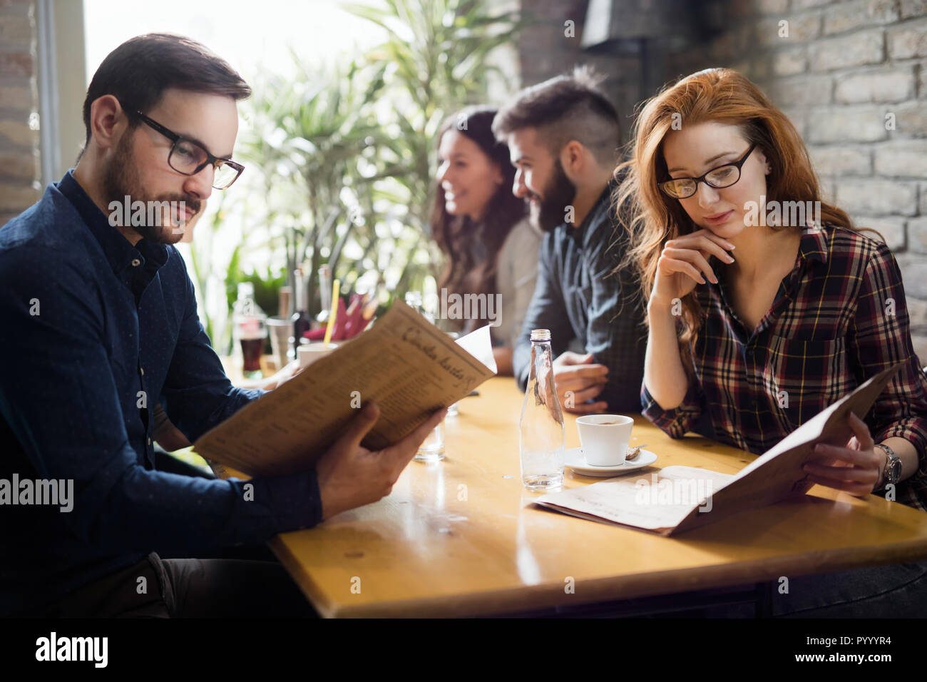 Happy colleagues from work socializing in restaurant Stock Photo - Alamy