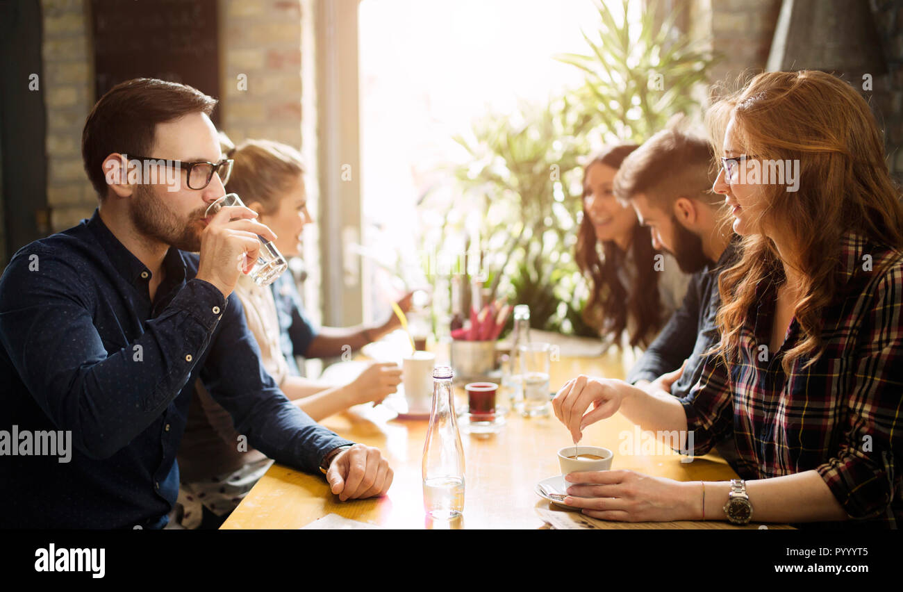 Happy colleagues from work socializing in restaurant Stock Photo - Alamy