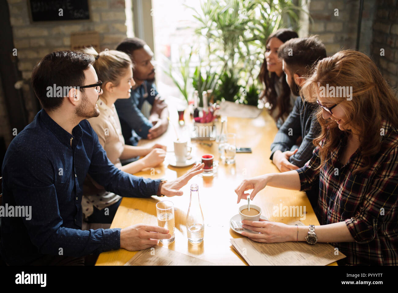 Happy colleagues from work socializing in restaurant Stock Photo - Alamy
