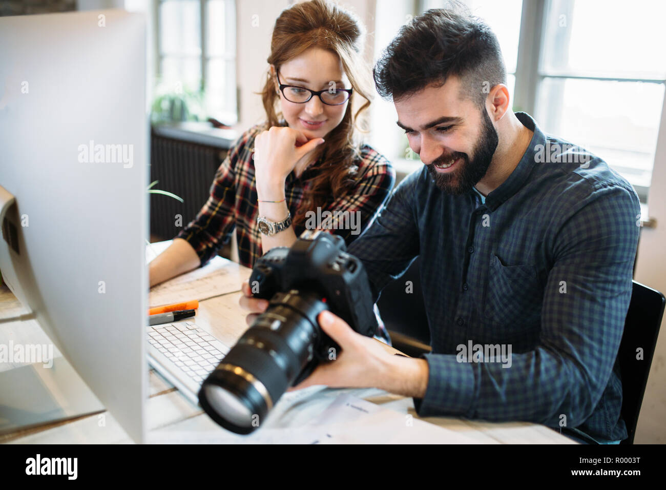 Two young designers working in modern office Stock Photo - Alamy