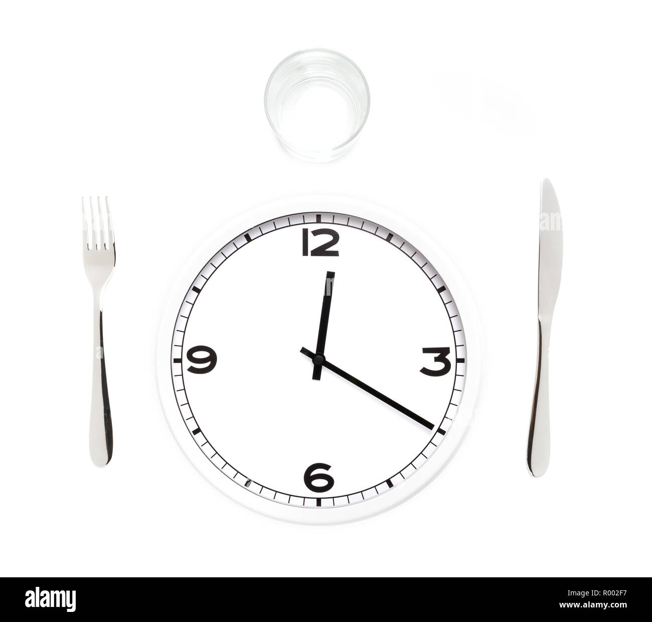 Fork, knife, glass, and white round clock isolated in white background ...
