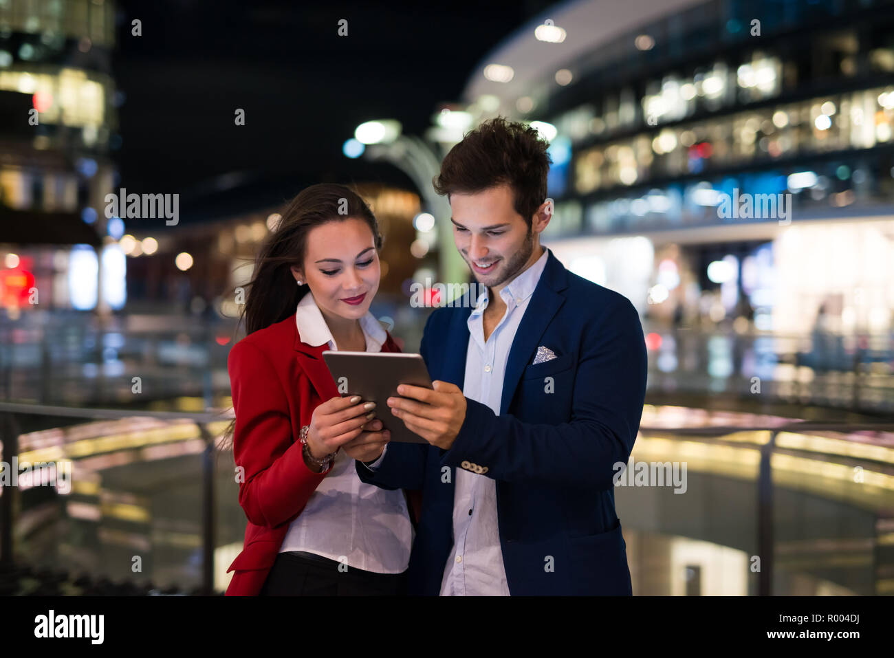 People using tablet at night in a city Stock Photo - Alamy