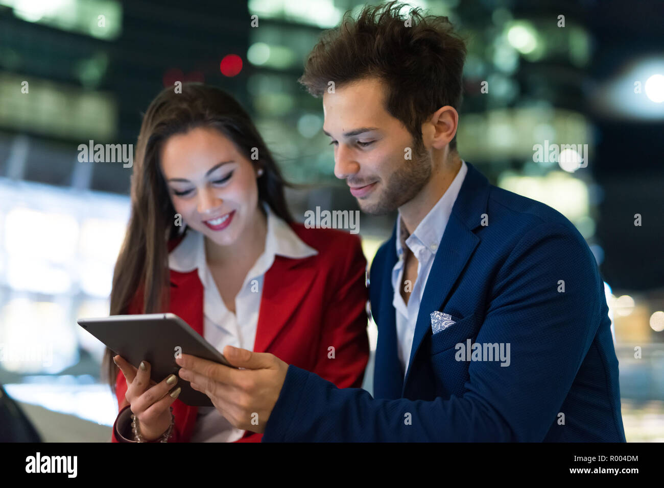 People using tablet at night in a city Stock Photo - Alamy