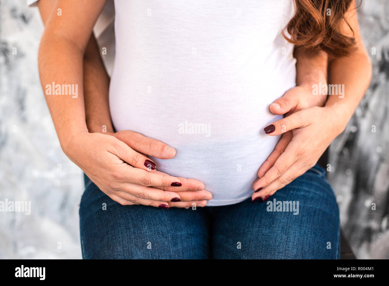 Pregnant couple hug and hold pregnant belly Stock Photo - Alamy