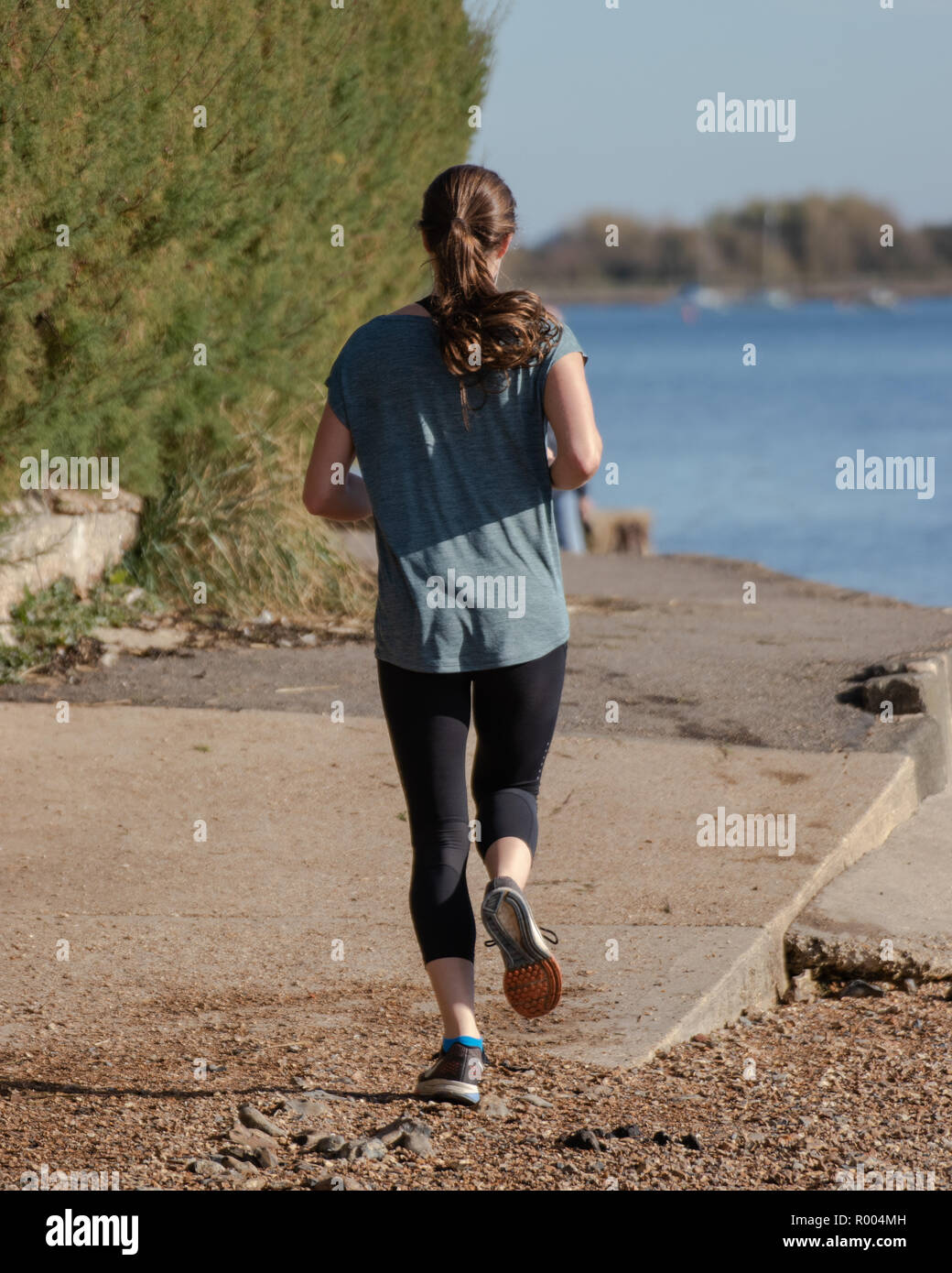 A young woman Jogging alone near the sea Stock Photo - Alamy
