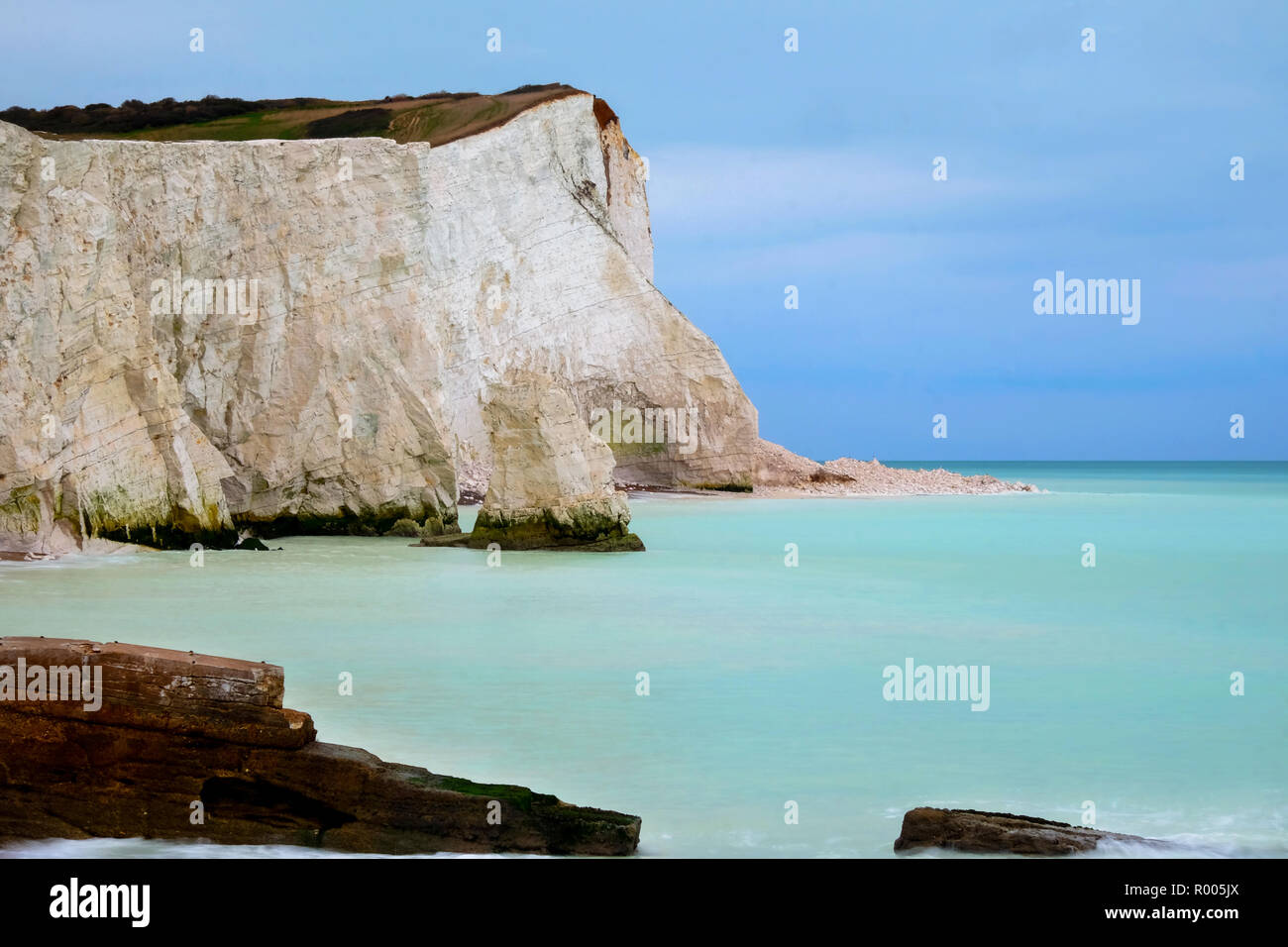Tall white chalk cliff face, at the bottom of the cliff is a large ...