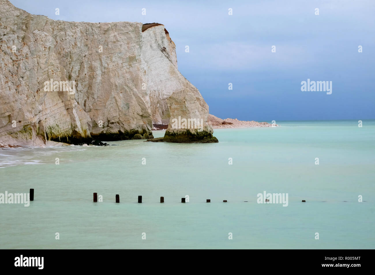 Tall white chalk cliff face, at the bottom of the cliff is a large ...