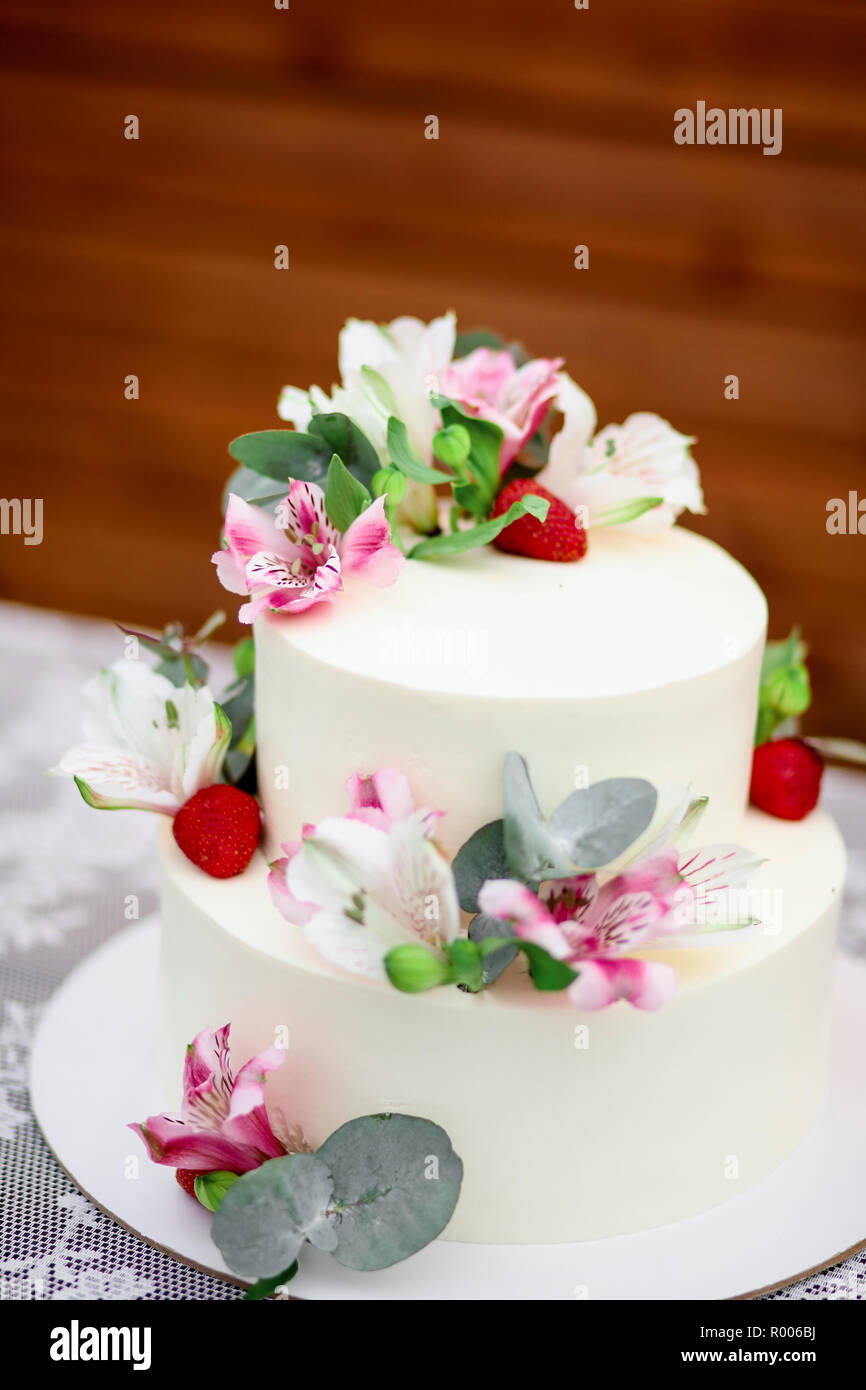 Delicious wedding cake decorated white icing with exotic flowers Stock ...