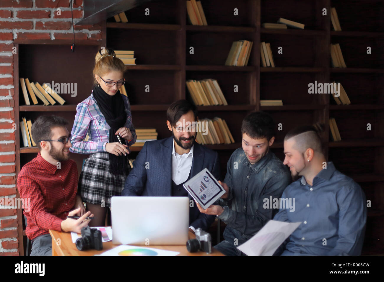 group of designers and photographers use a tablet computer for their ...