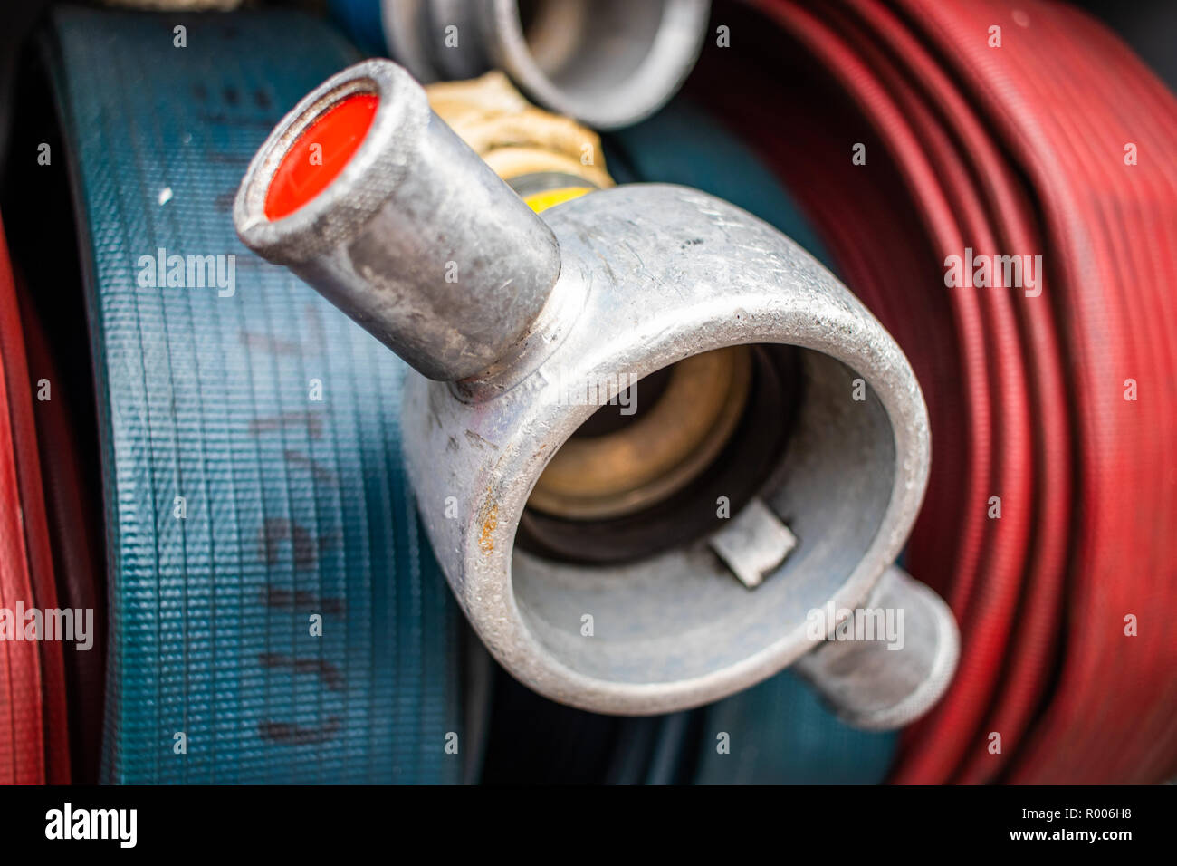 a coiled fire hose with steel nozzle Stock Photo - Alamy