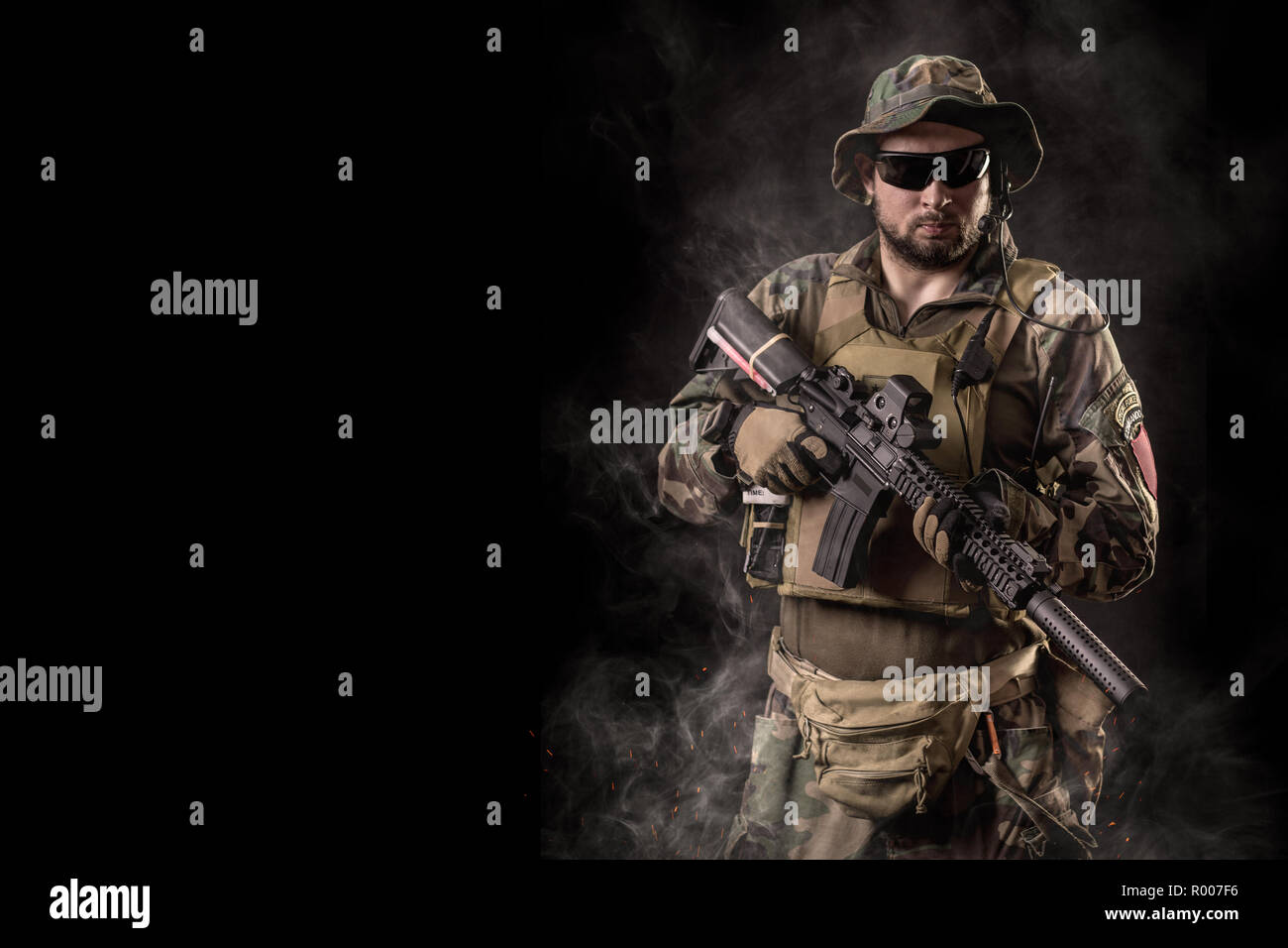 Special Forces soldier with an assault rifle on a black background ...