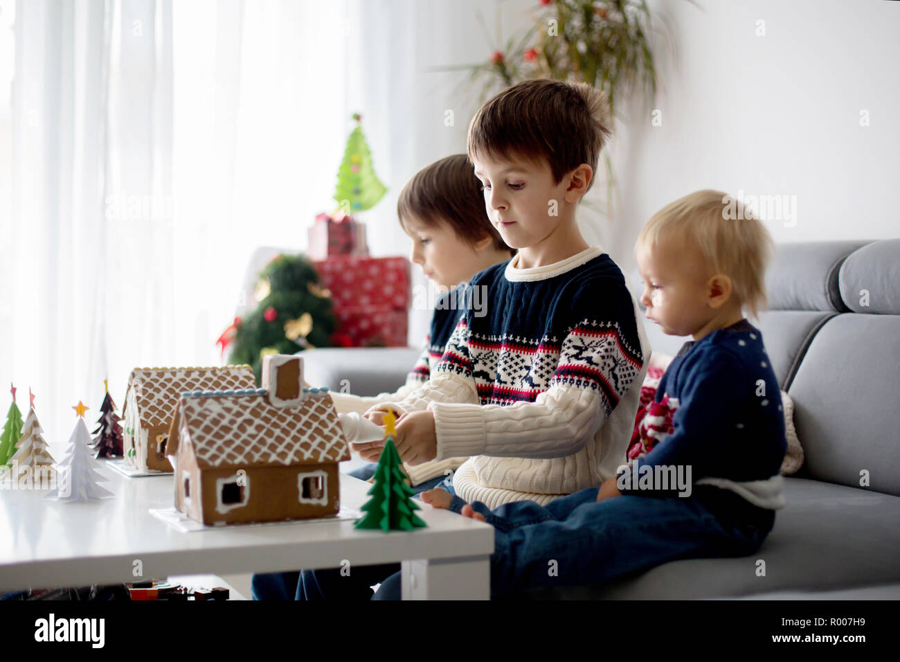Three sweet boys, brothers, making gingerbread cookies house ...