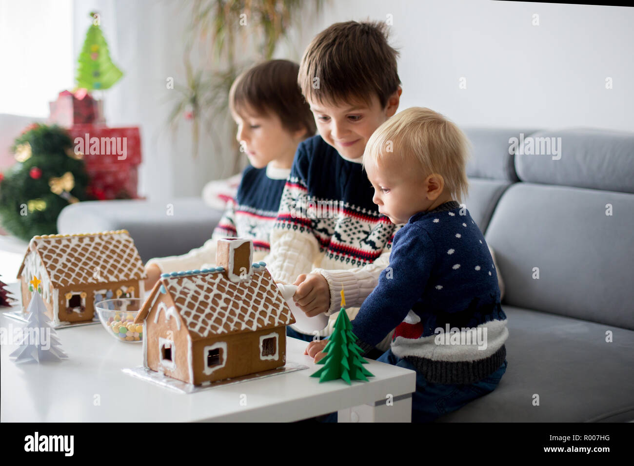 Three sweet boys, brothers, making gingerbread cookies house ...