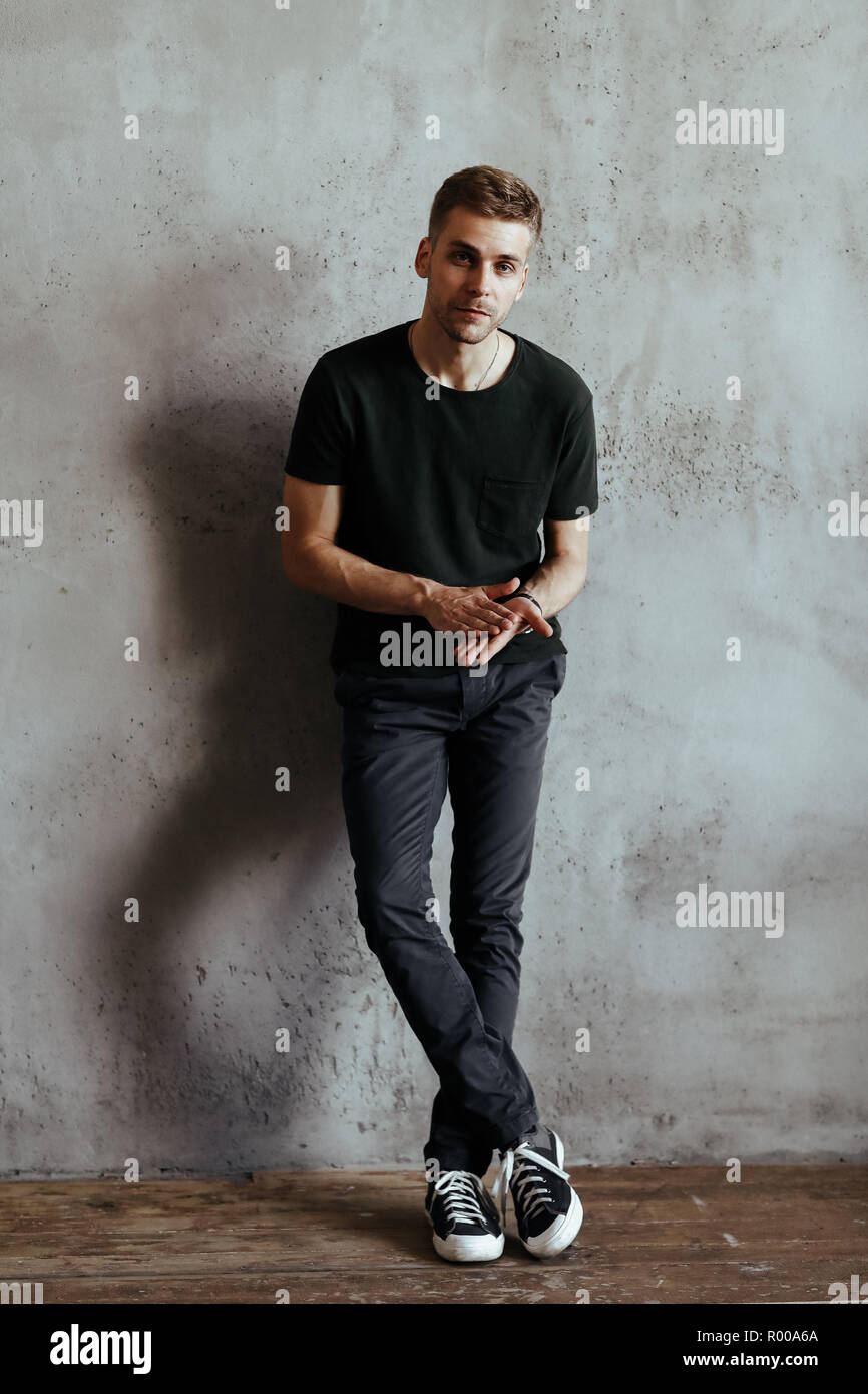 Happy, handsome man on a concrete wall background Stock Photo - Alamy
