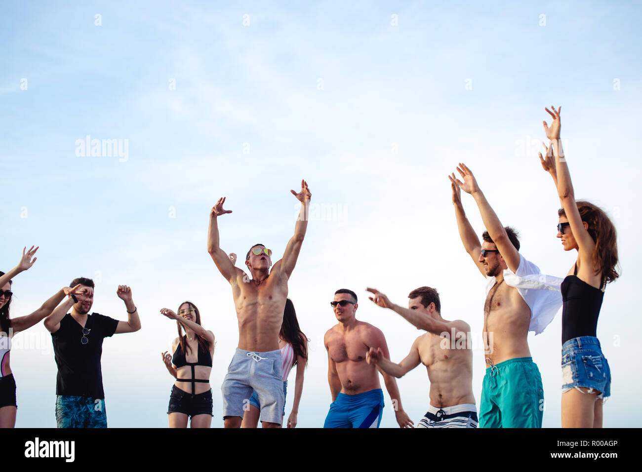 Friends dance on beach under sunset sunlight, having fun, happy, enjoy ...