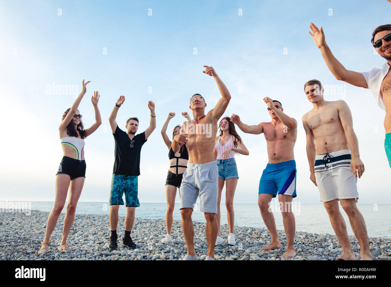 Friends dance on beach under sunset sunlight, having fun, happy, enjoy ...