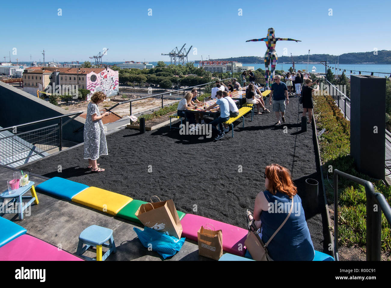 Rooftop bar with statue at the LX Factory under the suspension bridge ...