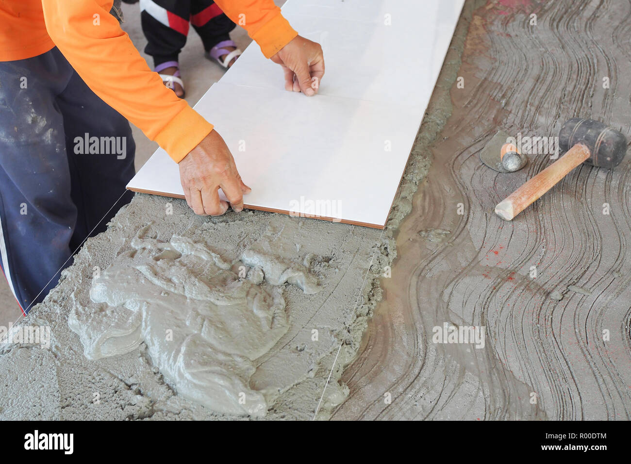 Construction worker tiler is tiling, Tiler installing ceramic tiles on ...