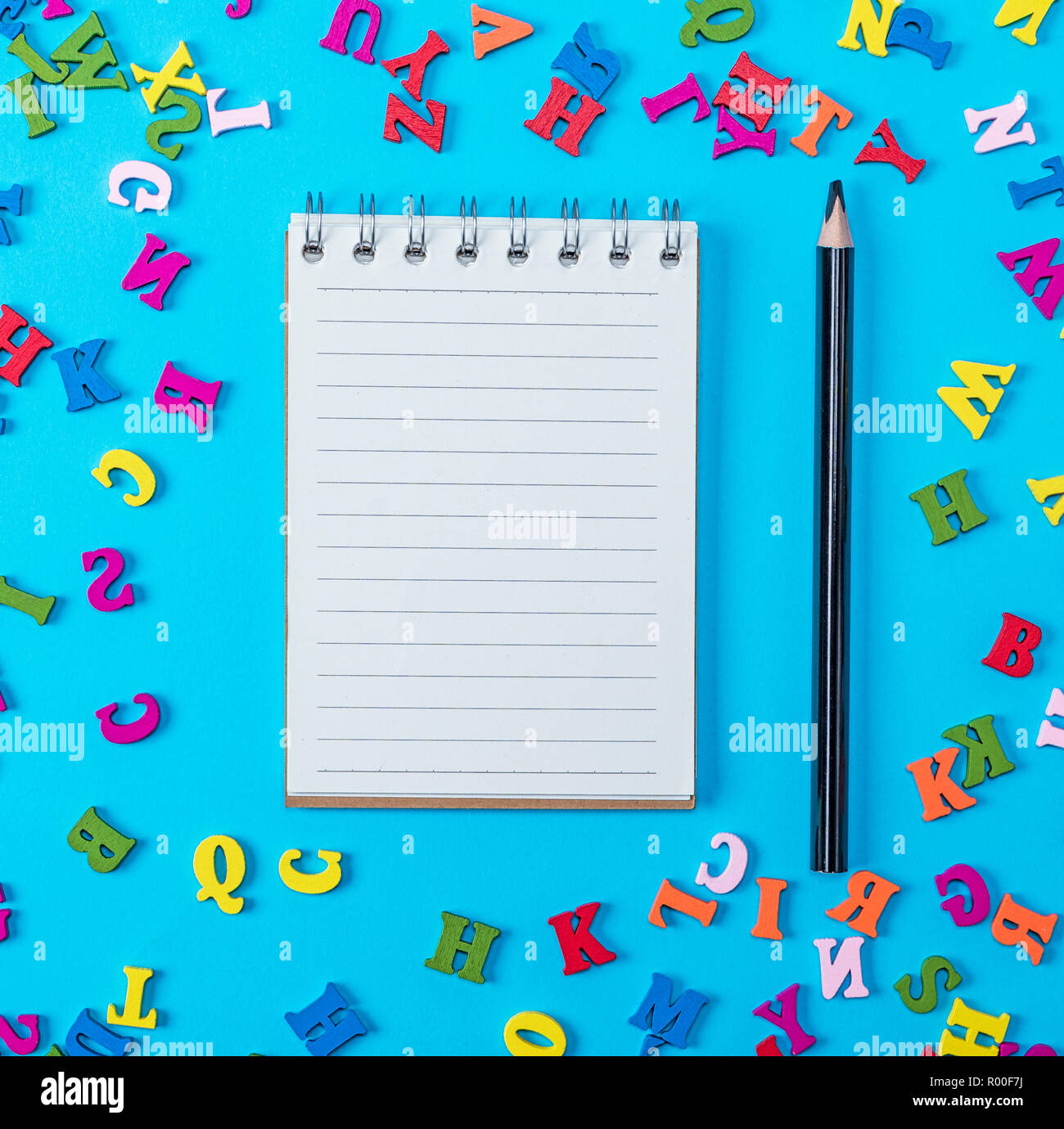 open notebook with empty white sheets, black pencil and wooden multi ...