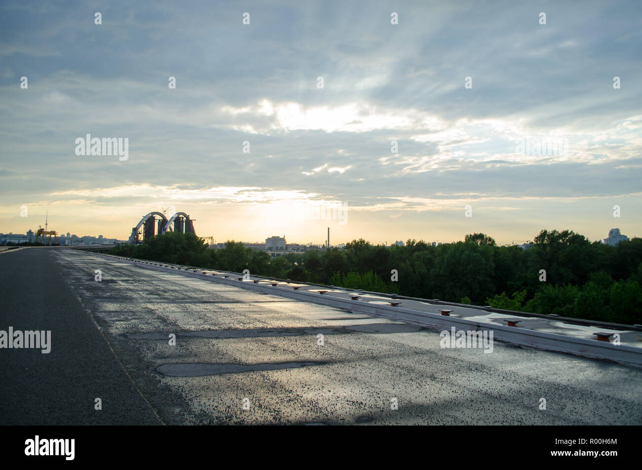 Abandoned road goes to the unfinished bridge. Industrial desolated ...