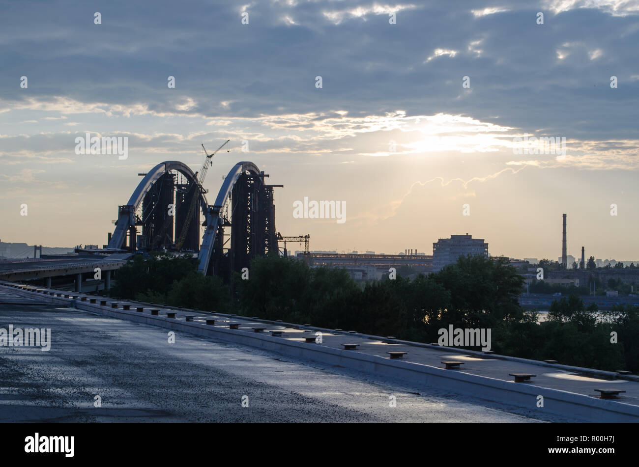 Abandoned road goes to the unfinished bridge. Industrial desolated ...